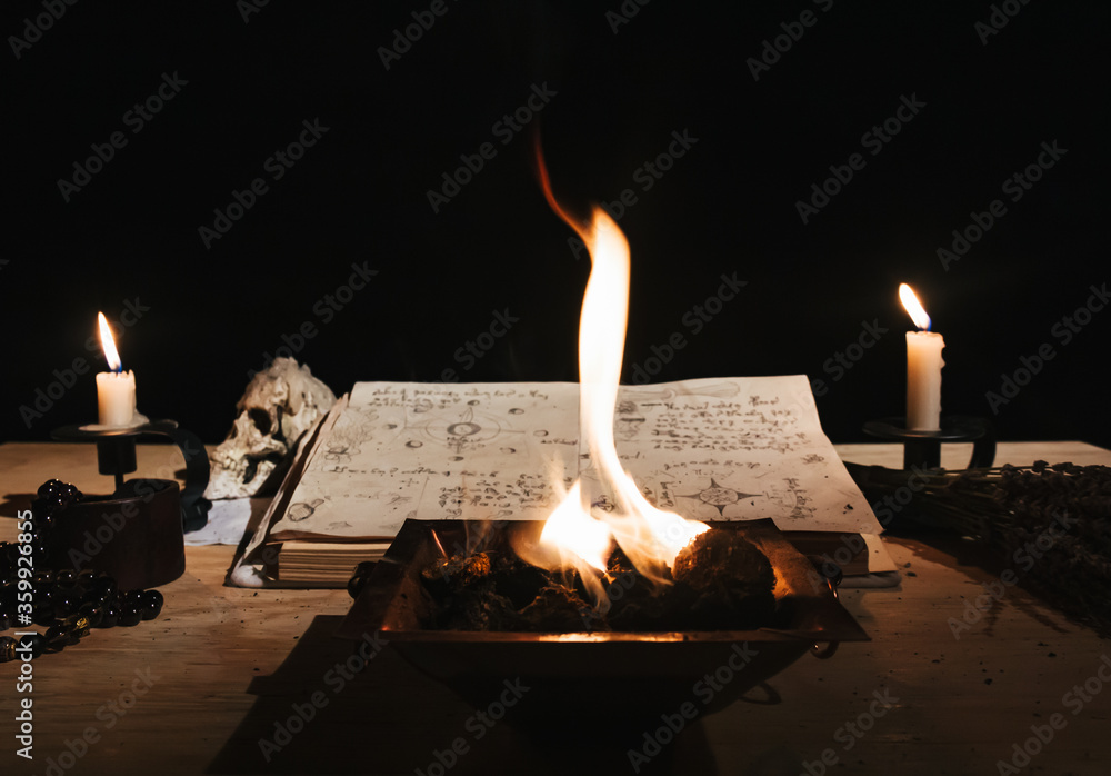 Occult white magic ritual of fire using grimoire, old book, candles ...