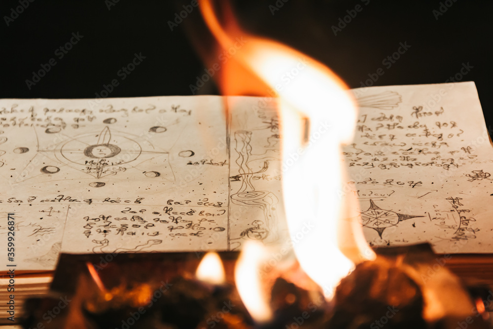 Occult white magic ritual of fire using grimoire, old book, candles ...