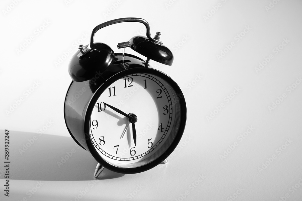 Black vintage alarm clock on table. White background. Wake up concept ...