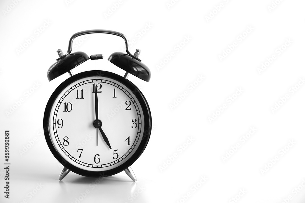 Black vintage alarm clock on table. White background. Wake up concept ...