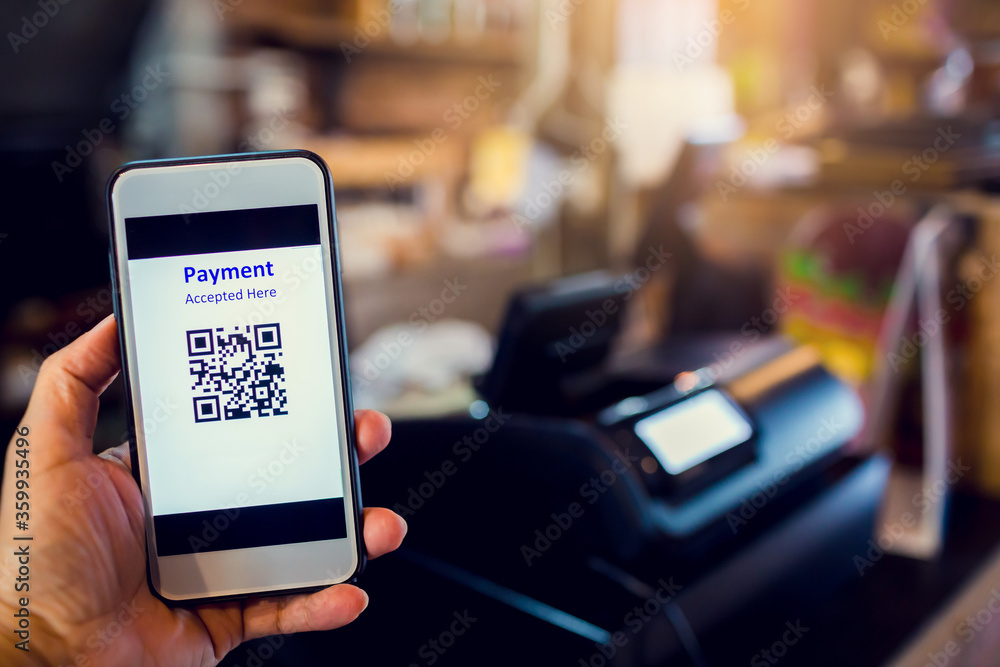 Scanning QR code payment with blurry cashier machine at counter service ...