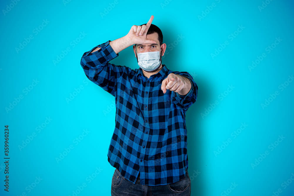 Closeup portrait serious young bearded man showing loser sign on ...