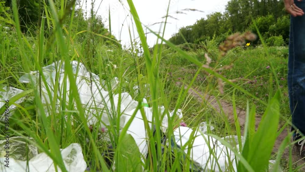a man throws a plastic bottle in the woods. Environmental pollution ...