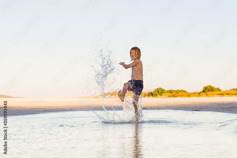 Kid splashing water on the beach Stock Photo | Adobe Stock