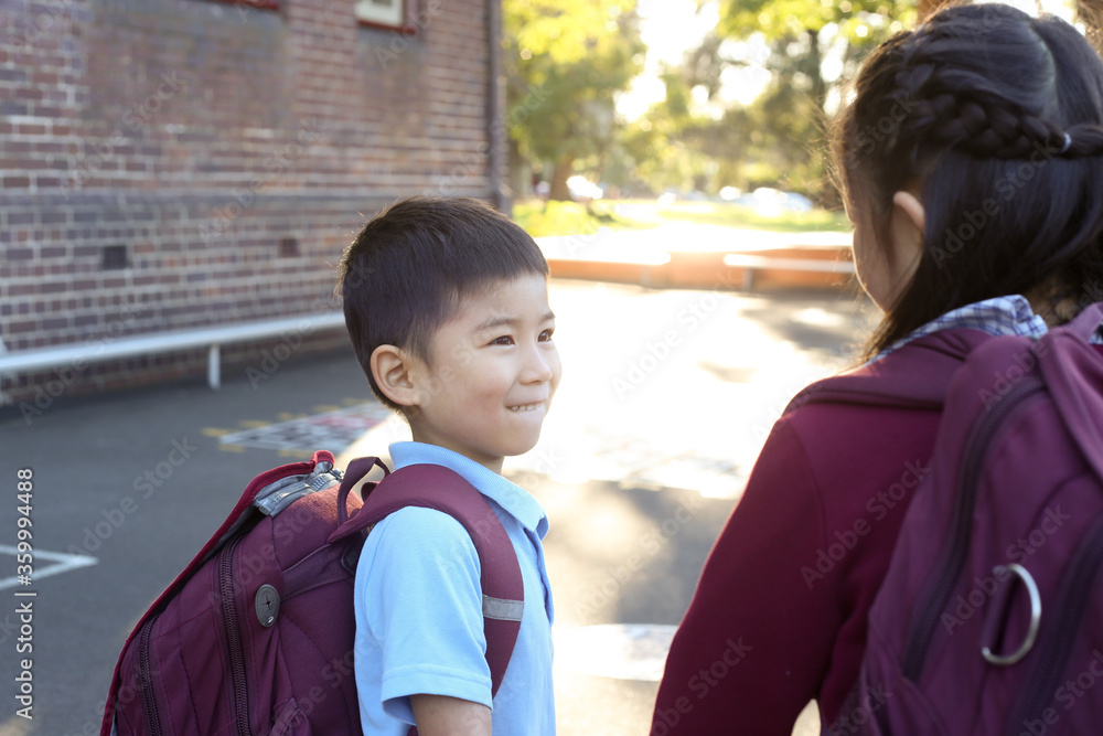 Two happy children talking in the playground as they leave school Stock ...
