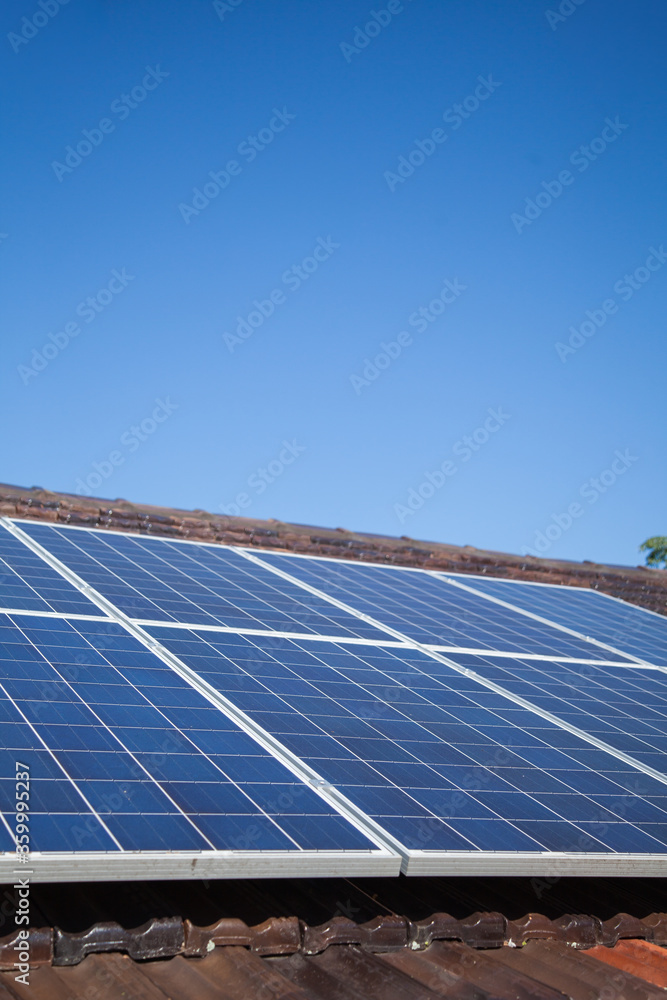 Solar panels installed on roof under blue sky Stock Photo | Adobe Stock