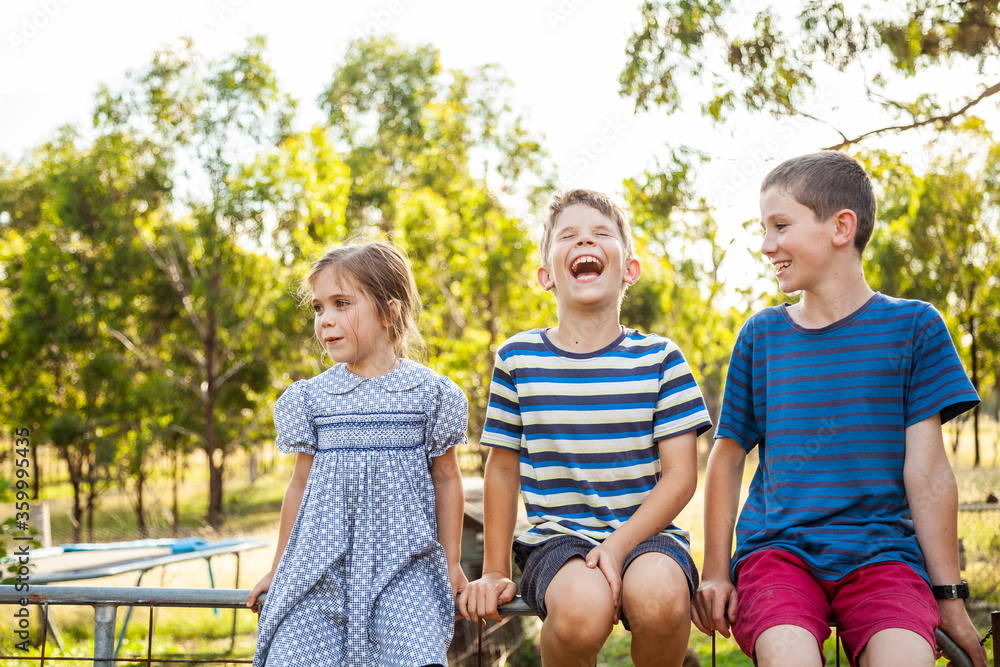 Three happy children laughing together outside Stock Photo | Adobe Stock