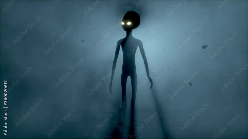 Scary gray alien walks and looks blinking on a dark smoky background ...