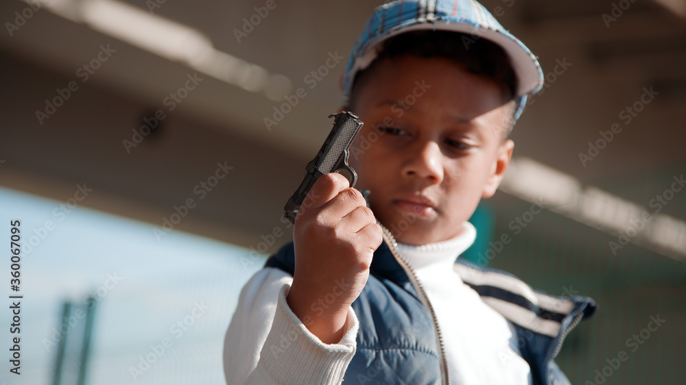 Black (african-american) kid playing the gangster with toy gun (pistol ...