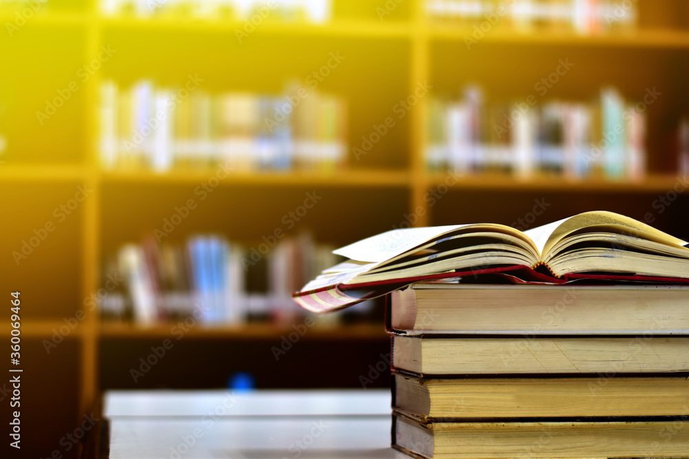 Open Book on wood table and blurred bookshelf in the library, education ...
