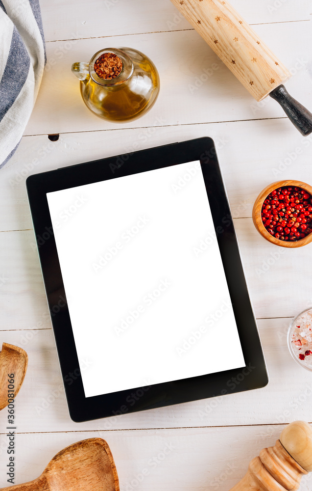 Tablet with blank screen and different kitchen and cooking utensils on ...