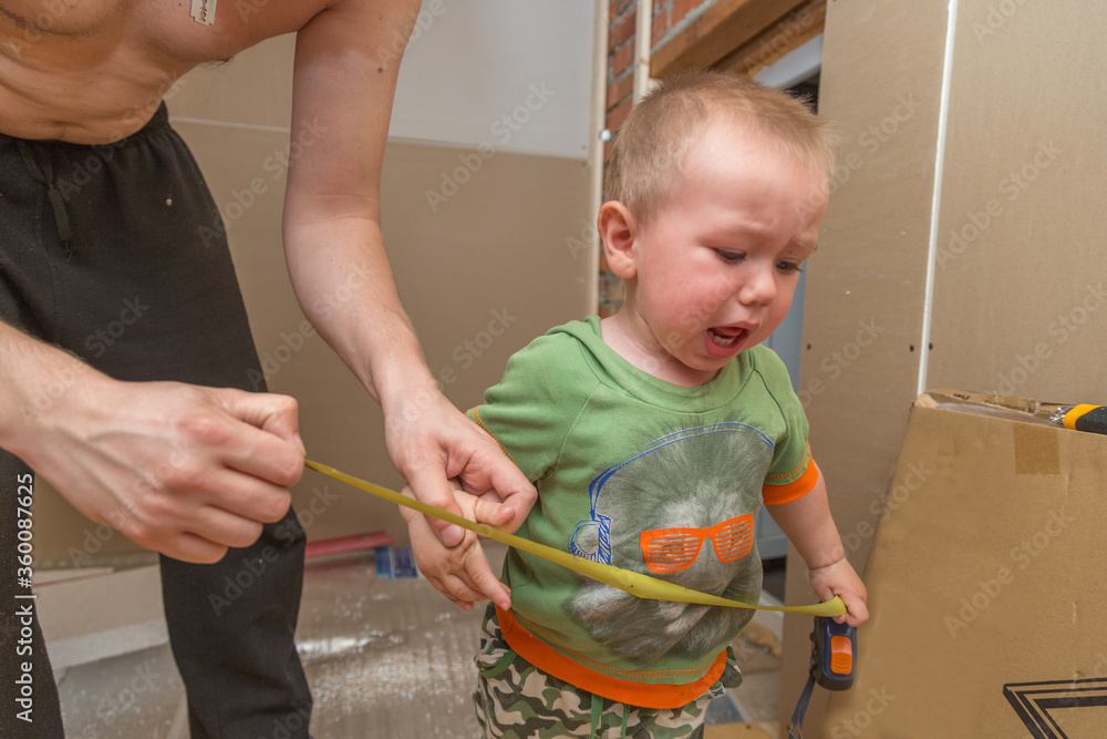 Crying boy with tape measure does work in the attic Stock Photo | Adobe ...