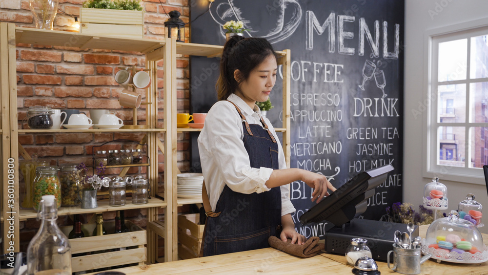 elegant smiling japanese shop assistant woman using pos point of sale ...