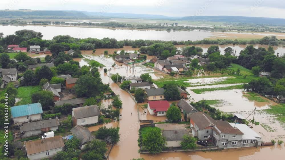 People who are in a flooded house by a river that overflowed after rain ...