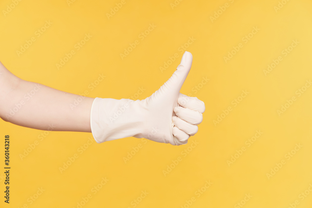 Horizontal photo of raised hand in white gloves showing thumb while ...