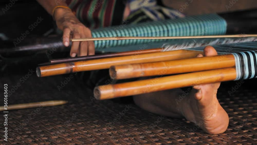 Laos, Pakse. Hands and feet of woman weaving in a traditional backstrap ...
