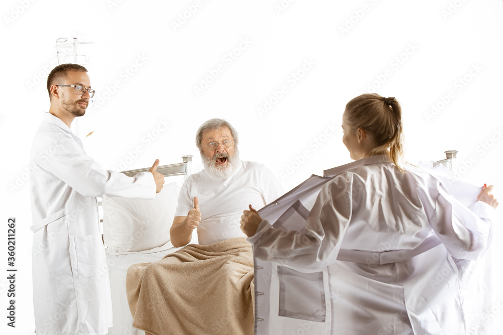 Elderly old man recovering in hospital bed isolated on white background ...