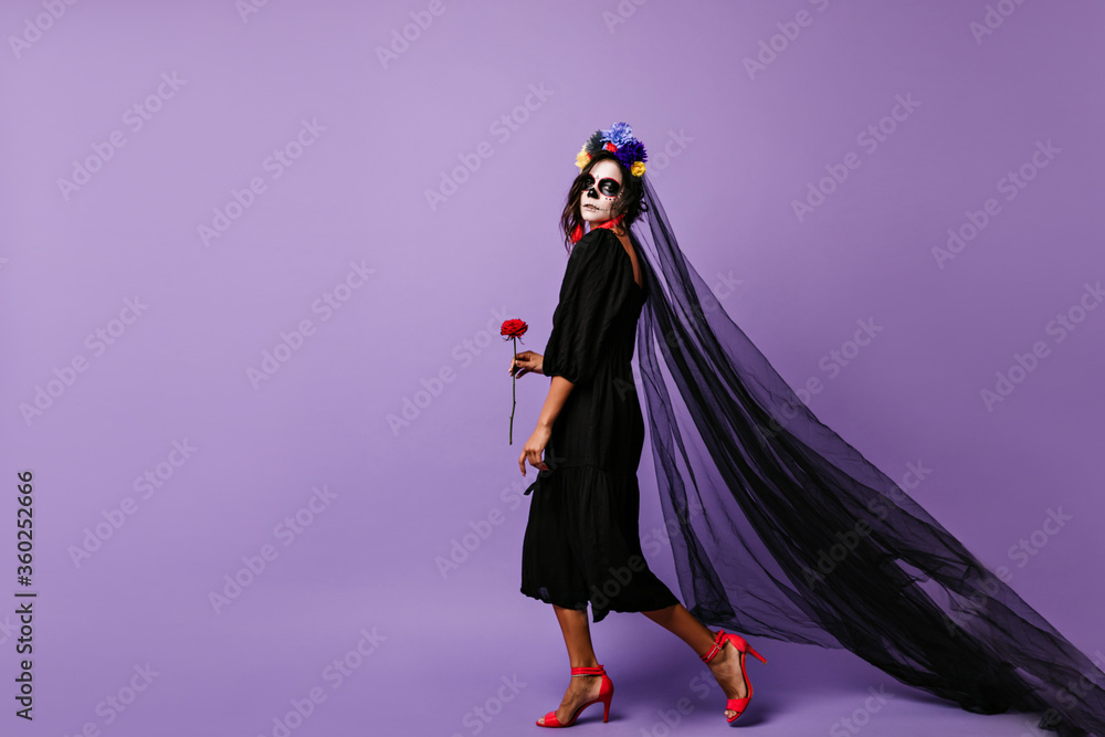 Full-length portrait of slim woman in dead bride costume. Serious girl ...
