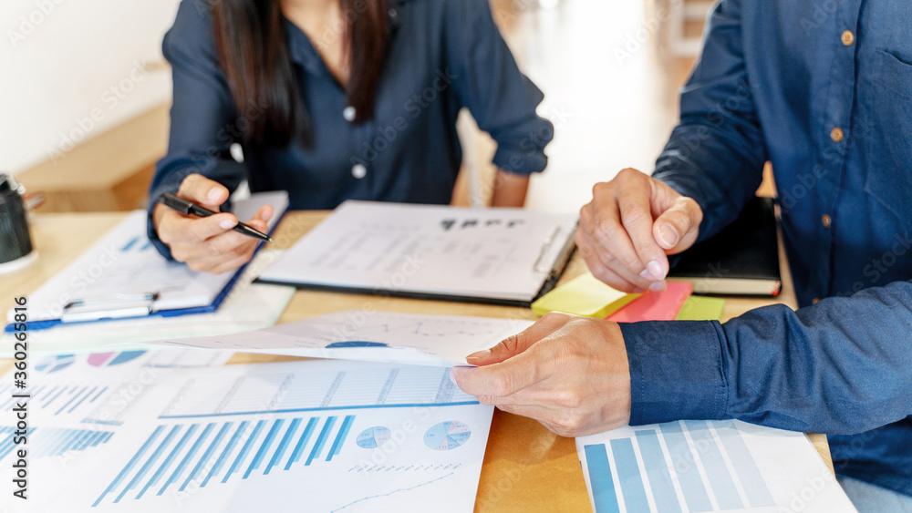 Two accountants working together with data documents of financial chart ...