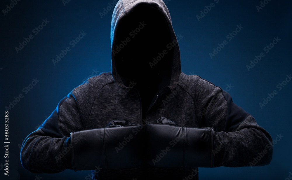 Dangerous hooded hacker without face in boxing gloves. Internet, cyber crime, cyber attack ...