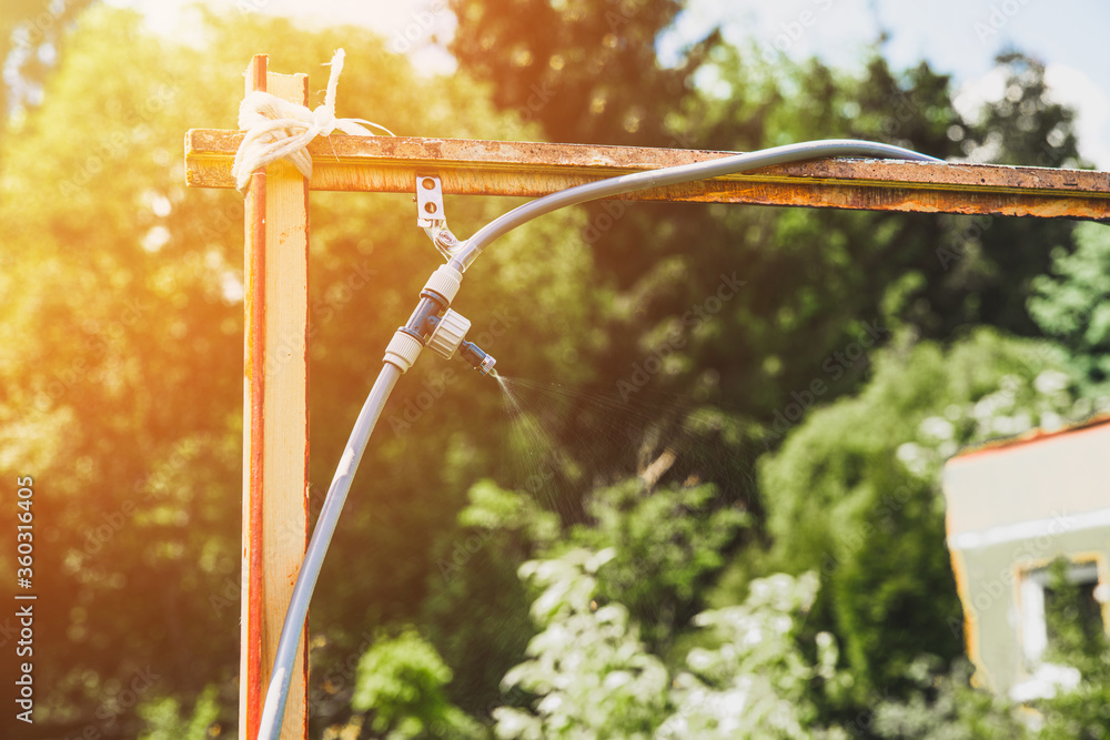 Cooling in the heat, warm summer. Water mist cools, dispersed on the ...