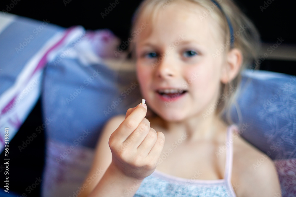 A beautiful little girl of 6-7 years old lost the first milk tooth ...