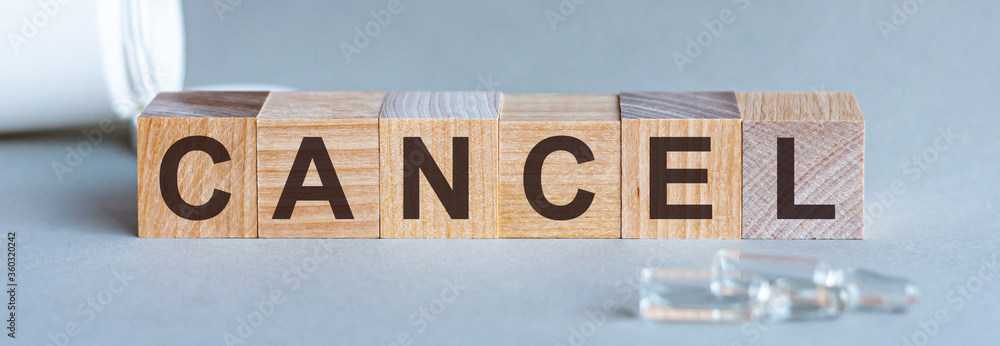 CANCEL word made with building blocks, grey background. in the ...