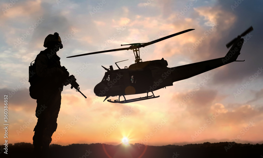 Military soldier standing on open field with automatic weapon in front ...