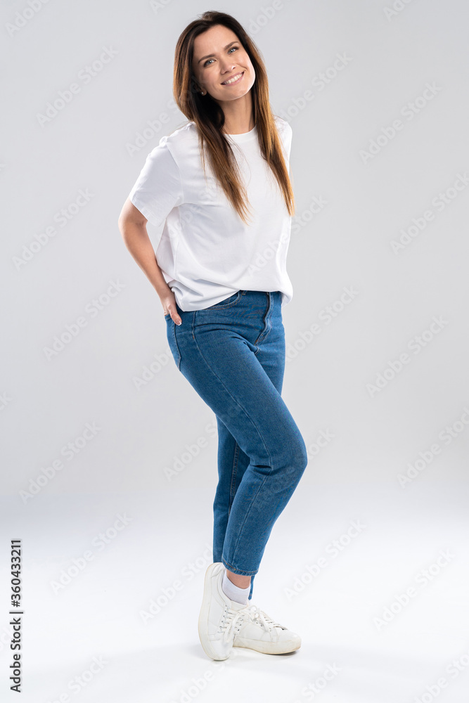 Full portrait of a beautiful young happy woman standing over white ...