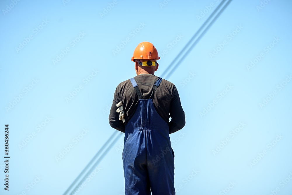 road worker in a hard hat and overalls. Construction of roads and ...