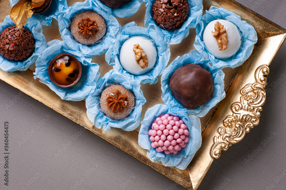 .Various types of gourmet brigadeiro on a golden tray. Typical sweet ...