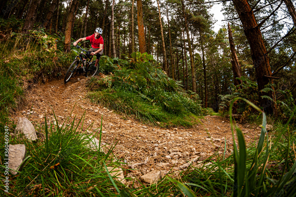 BALLINASTOE, IRELAND. A mountain biker riding a tight corner on a trail ...