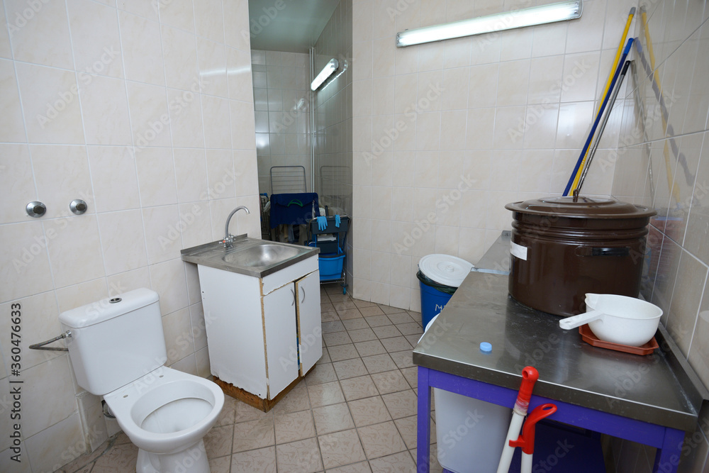 Hospital utility room: bath, biffy, washing-machine mops and buckets ...