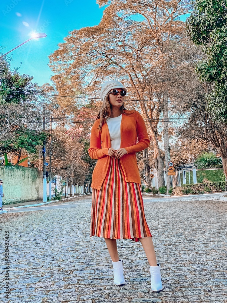 Beautiful model posing for street photos. Wearing orange clothes. Stock ...