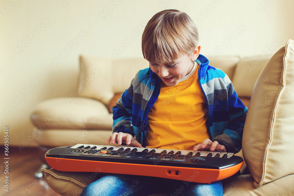 Cute schoolboy playing on synthesizer at home. Children's piano ...