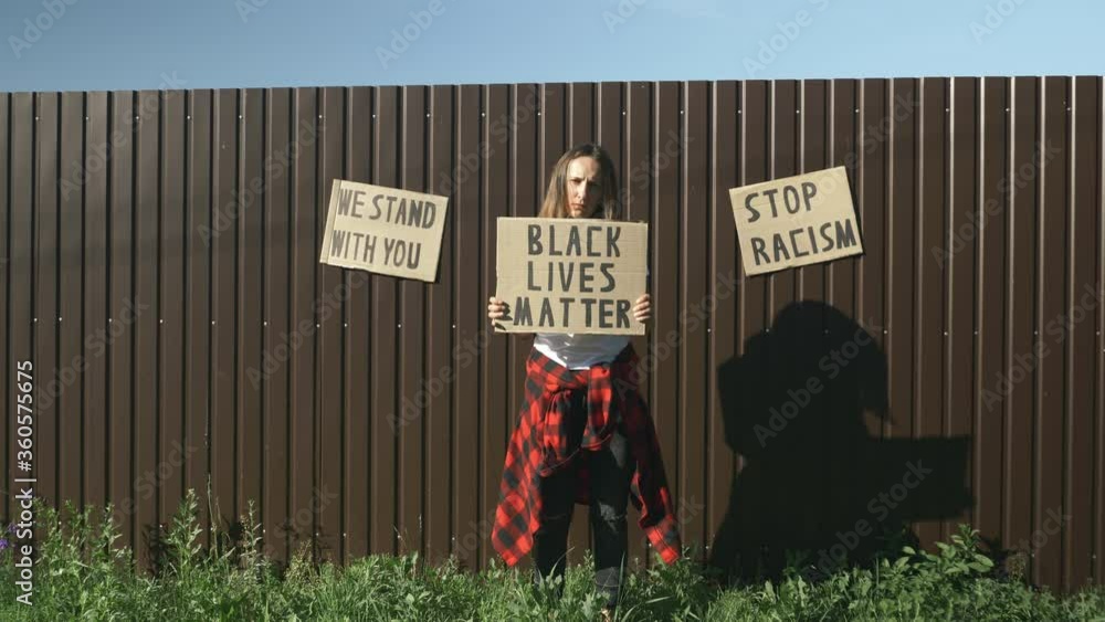 Young millennial caucasian woman holding sign "black lives matter ...