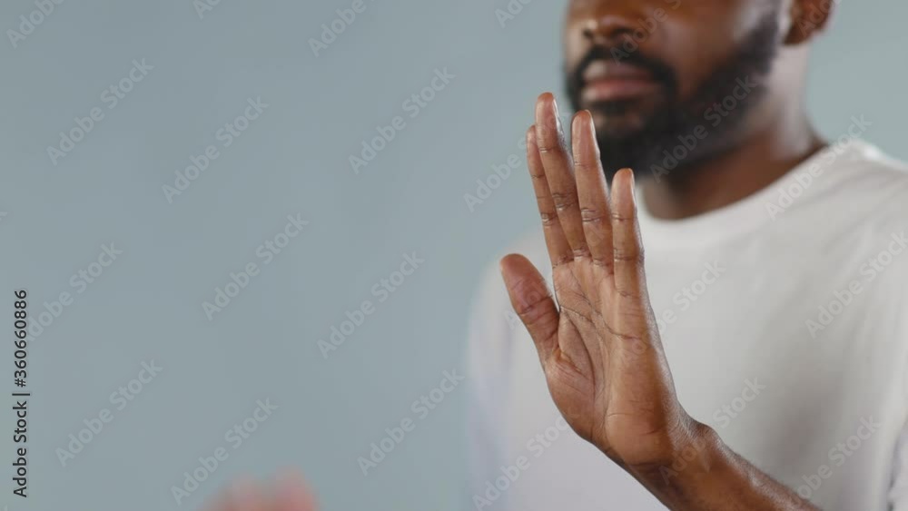 On grey background white hand and black hand are given the five stop ...