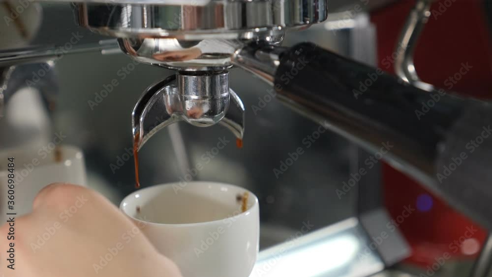 Making fresh coffee beverage going out from coffee espresso machine ...