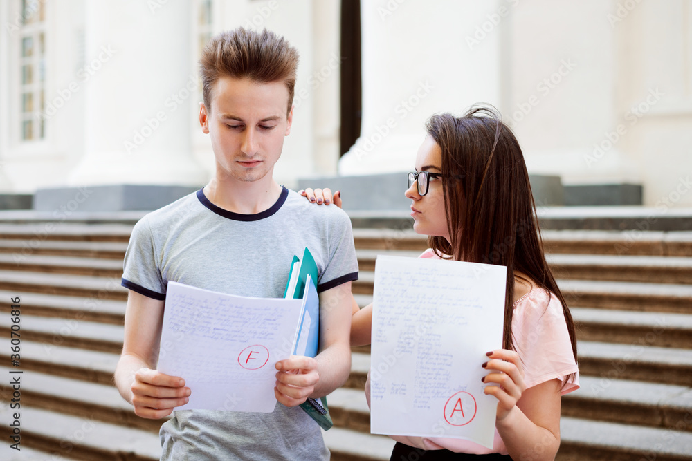 Two students with test results. Female student have received excellent ...
