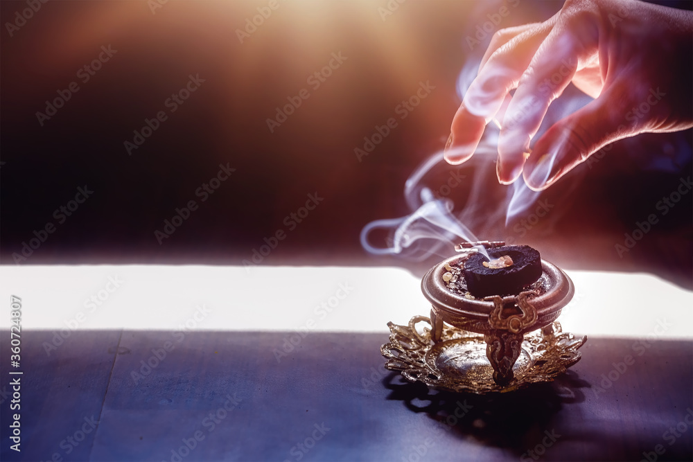 incense in a woman hand, incense smoke on a black background. Stock ...
