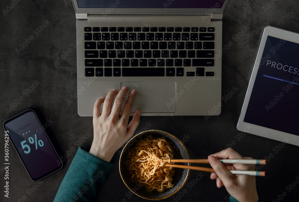 Woman Eating Noodle while Working on Computer Laptop, Mobile Phone and ...