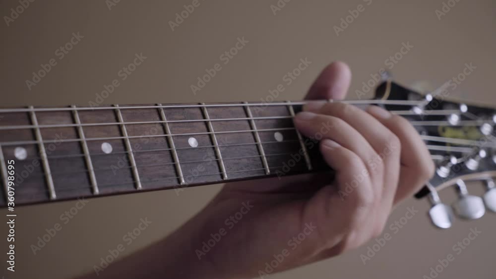 Male hands on guitar fretboard playing chords. Close up of guitarist ...