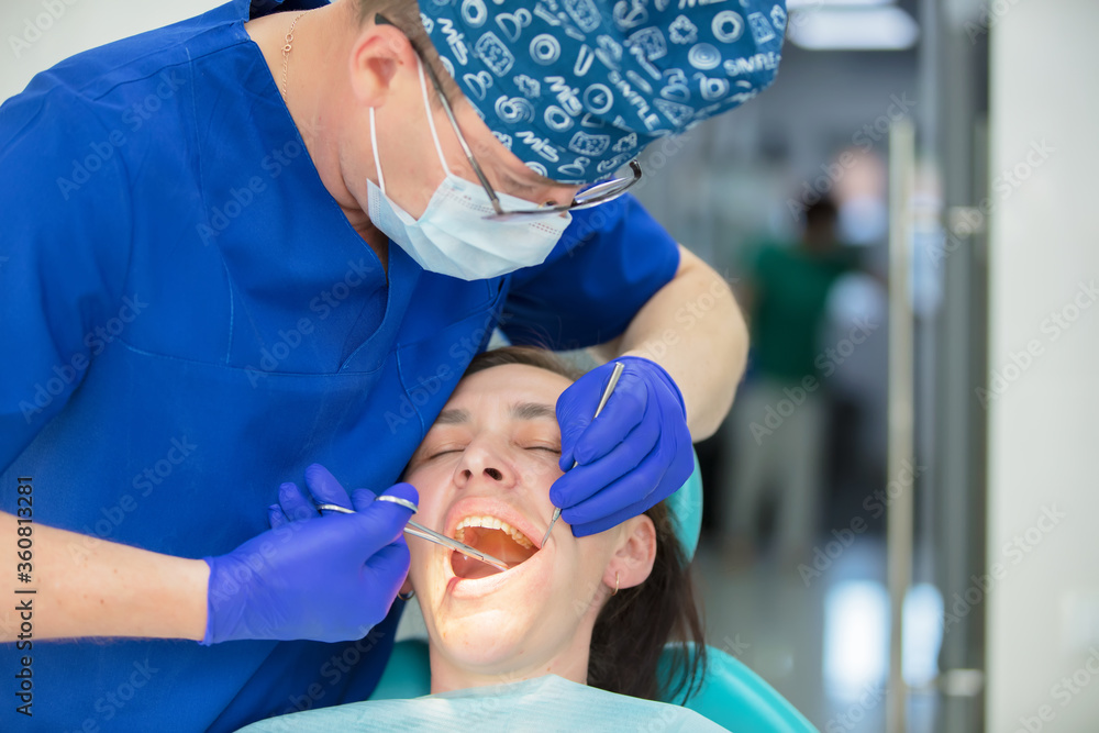 Dental treatment. Dental office. Doctor treats teeth. Woman in ...