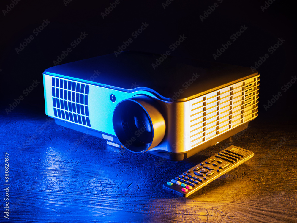 Projector on a dark background. Remote control from projector. Concept ...
