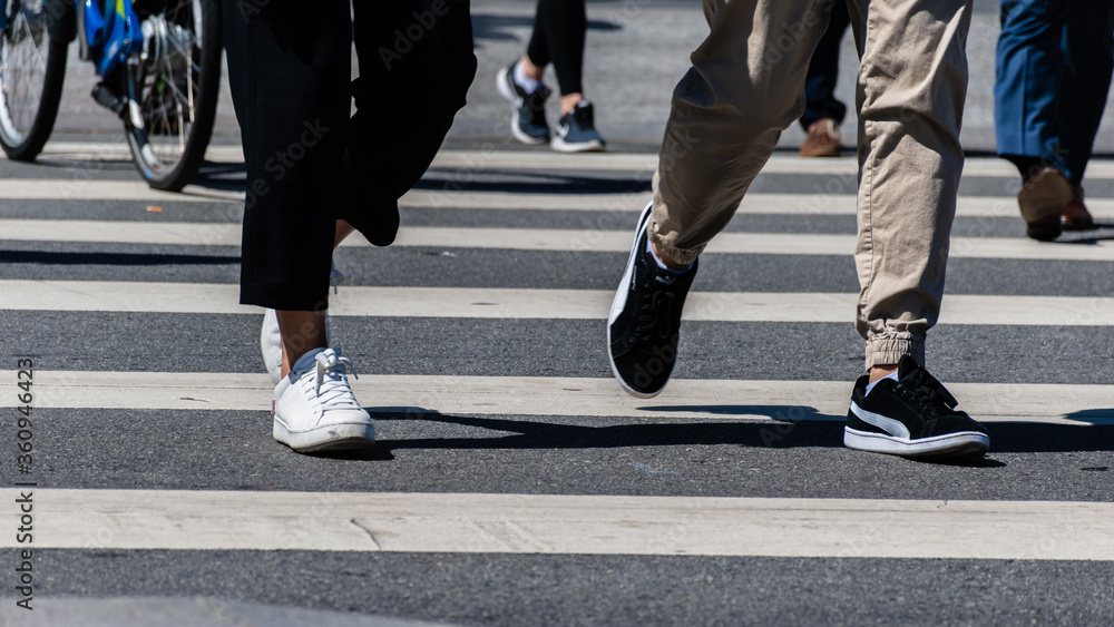 People legs and shoes walking on crosswalk busy street close up in the ...