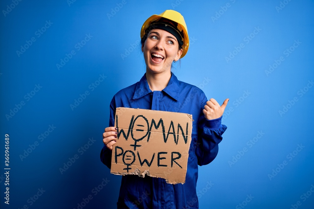 Young blonde worker woman asking for women rights holding banner with ...