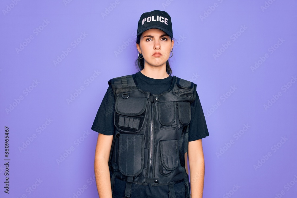 Young police woman wearing security bulletproof vest uniform over ...