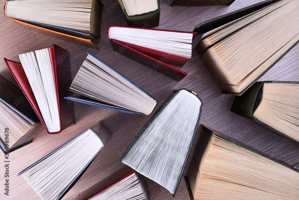 Books top view. They stand ajar on the table, the sheets spread out ...