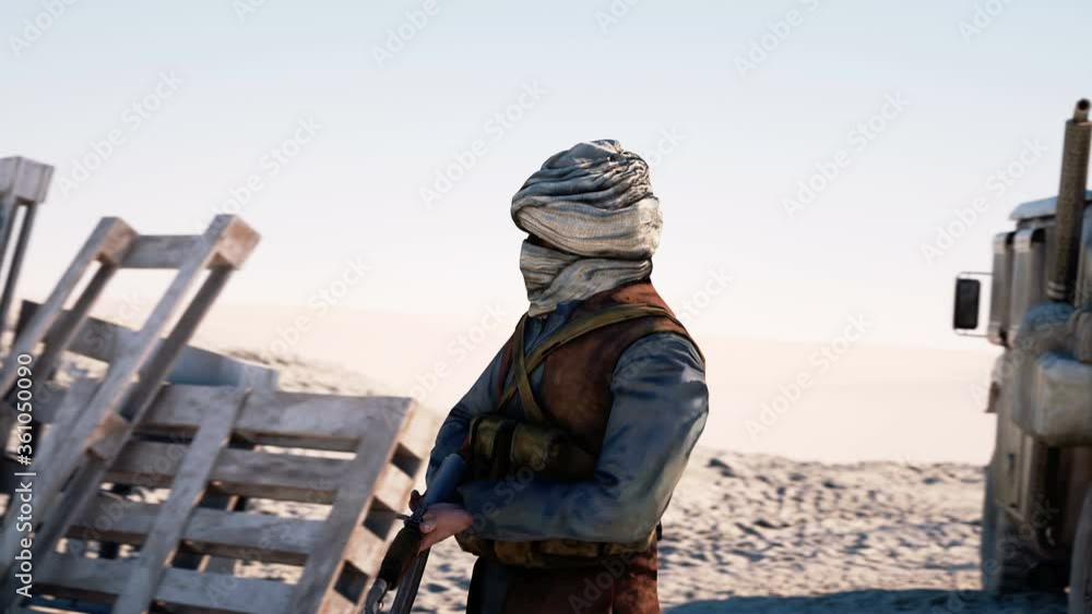 Man terrorist wearing a mask and holding a gun. East desert landscape ...
