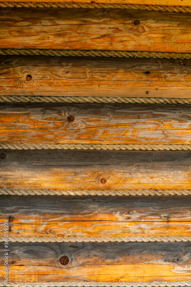 Wall in a log building with horizontal logs and a rope. Historical ...